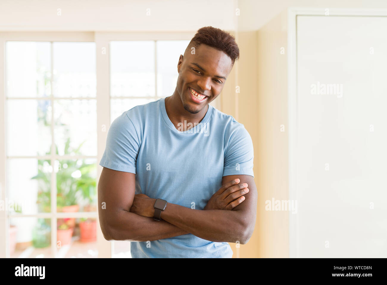 Handsome african young man smiling cheerful with crossed arms Stock ...