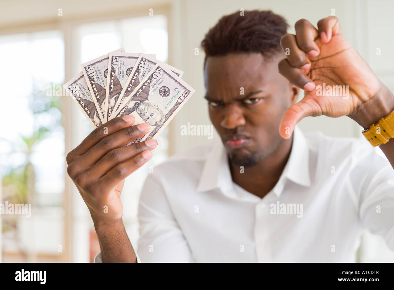 African american man holding fifty dollars bank notes with angry face ...
