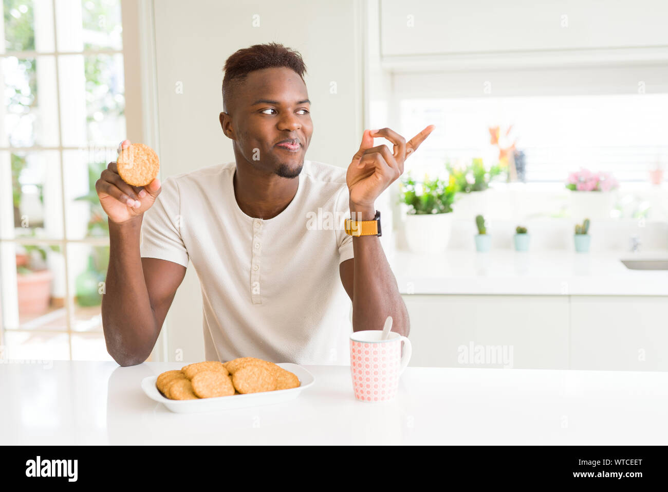 African american man eating healthy whole grain biscuit very happy ...