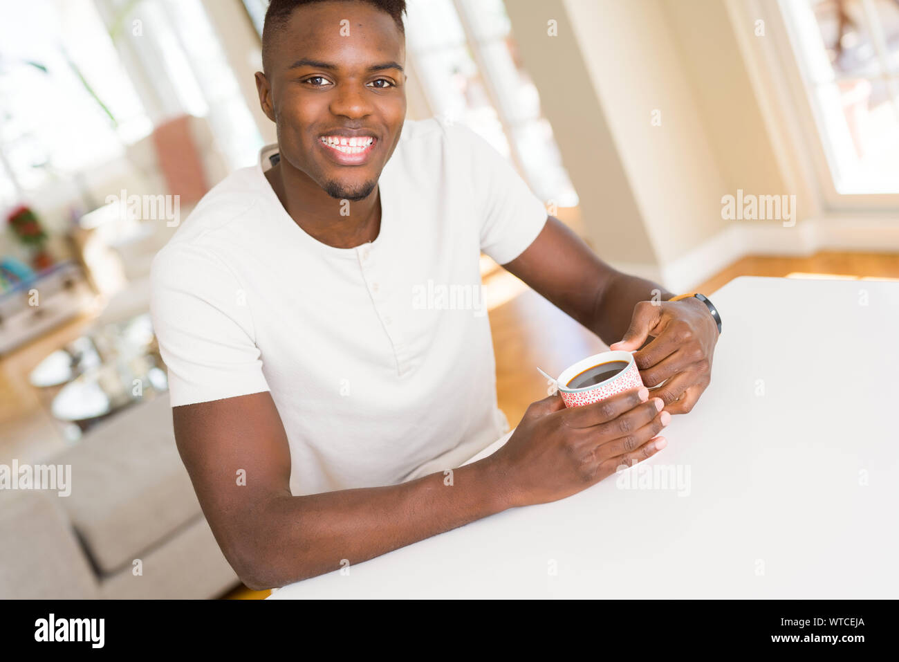African american man smiling confident drinking a coffee at home Stock ...
