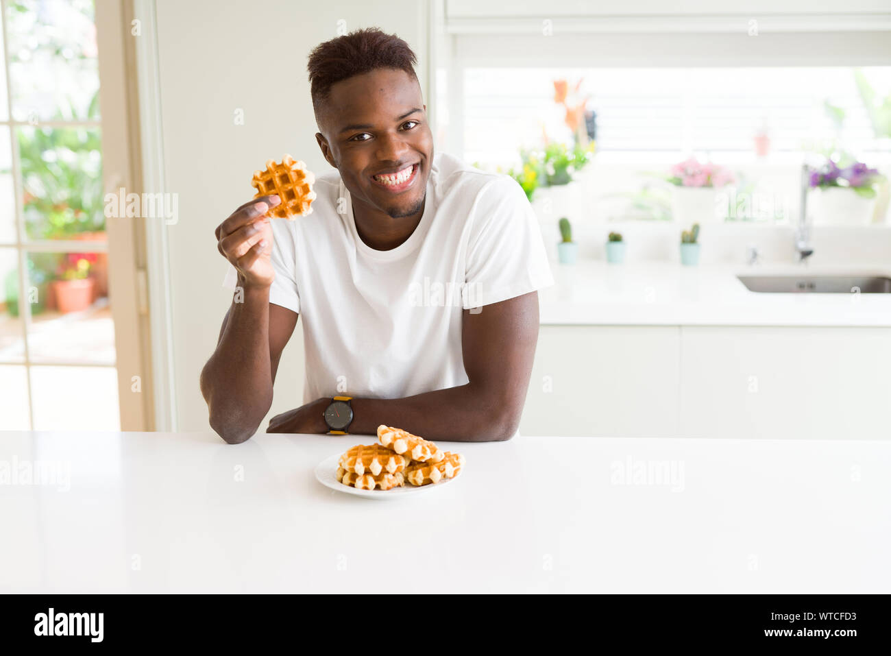 African american man eating sweet Belgian waffle with a happy face ...
