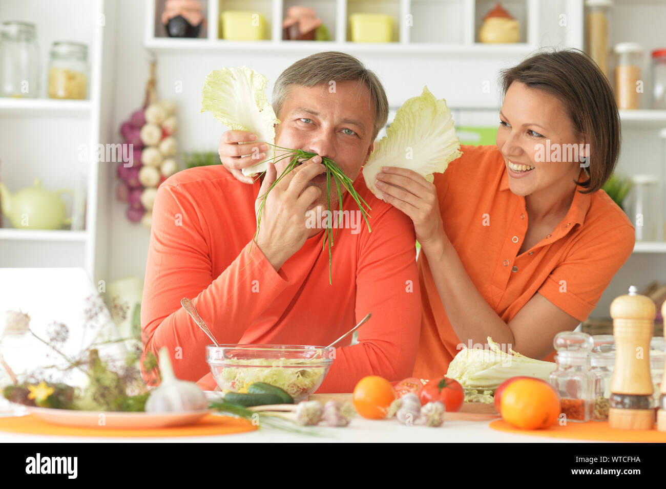 Happy married couple cooking together on kitchen at home Stock Photo ...