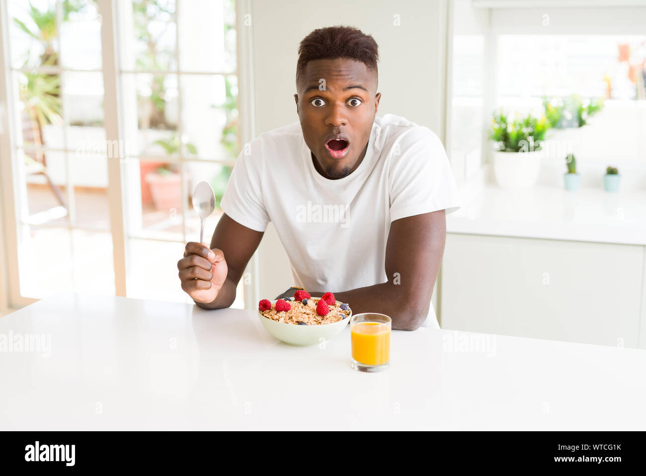 Young african american man eating healthy breakfast in the morning ...