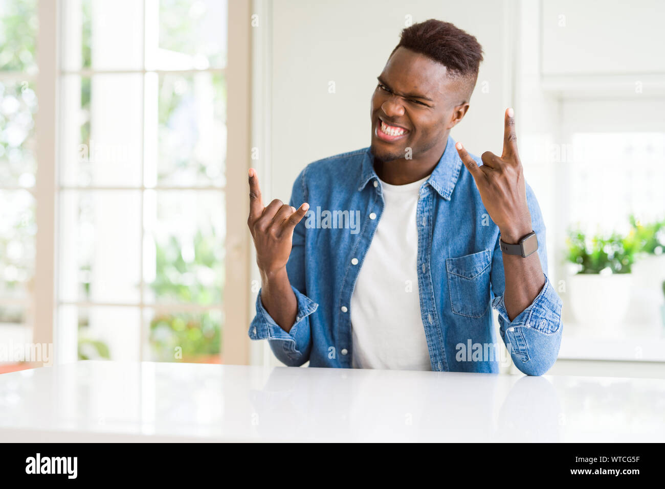 Handsome african american man at home shouting with crazy expression ...