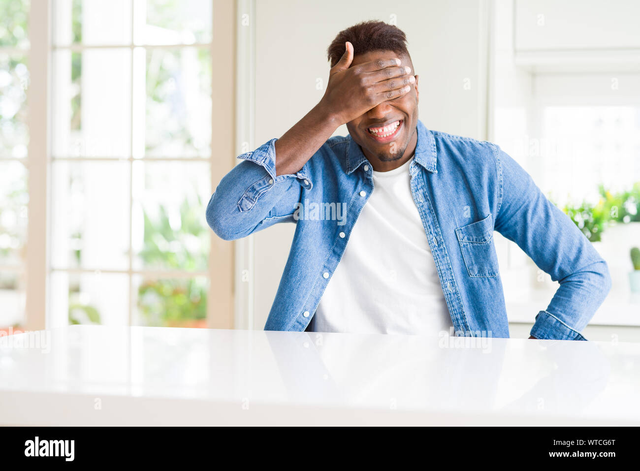 Handsome african american man at home smiling and laughing with hand on ...