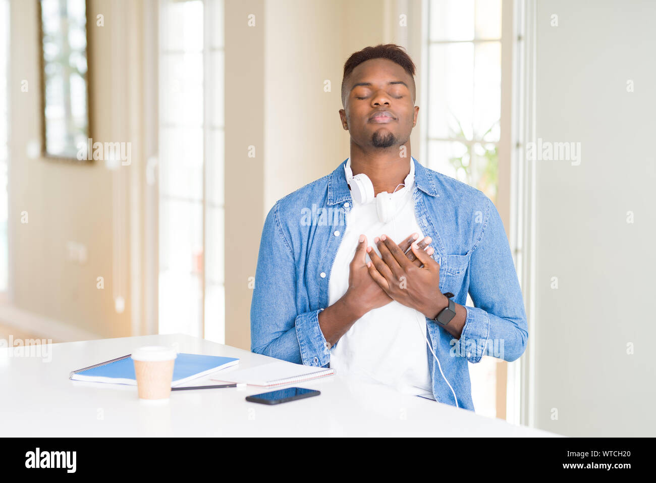 African american student man studying using notebooks and wearing ...