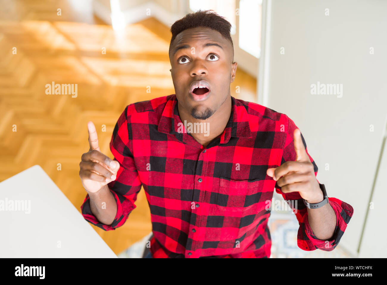 Overhead angle of handsome african american man amazed and surprised ...
