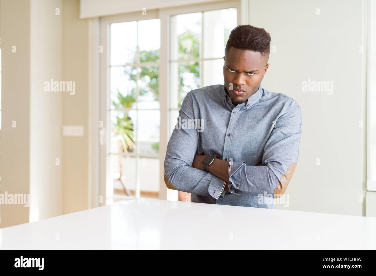 Handsome african american man on white table skeptic and nervous ...