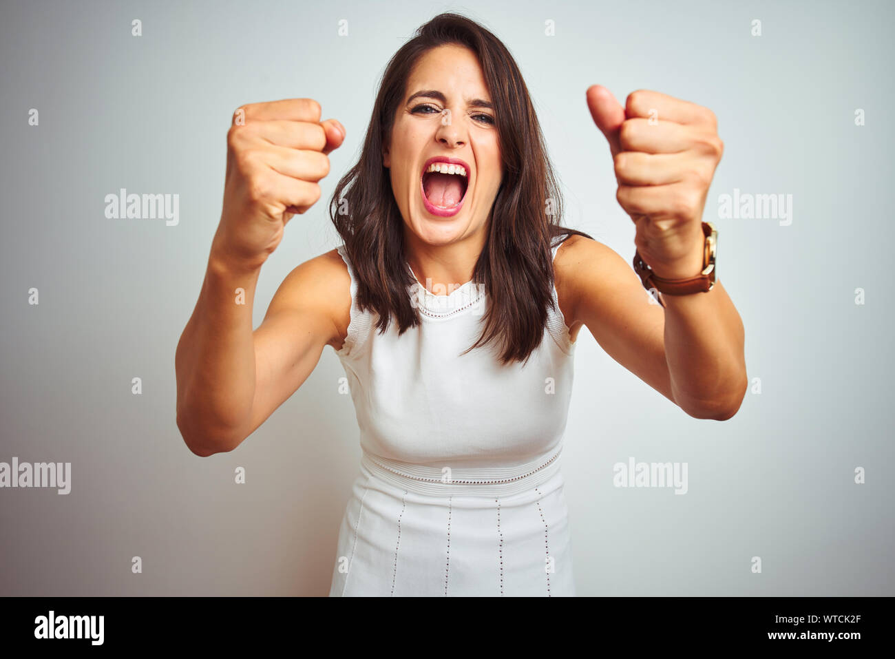 Young beautiful woman wearing dress standing over white isolated ...