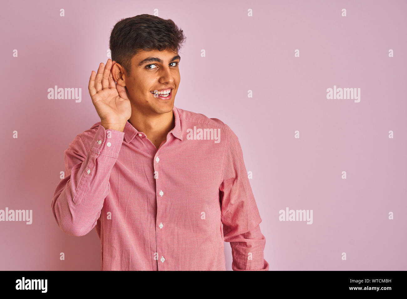 Young indian man wearing elegant shirt standing over isolated pink ...