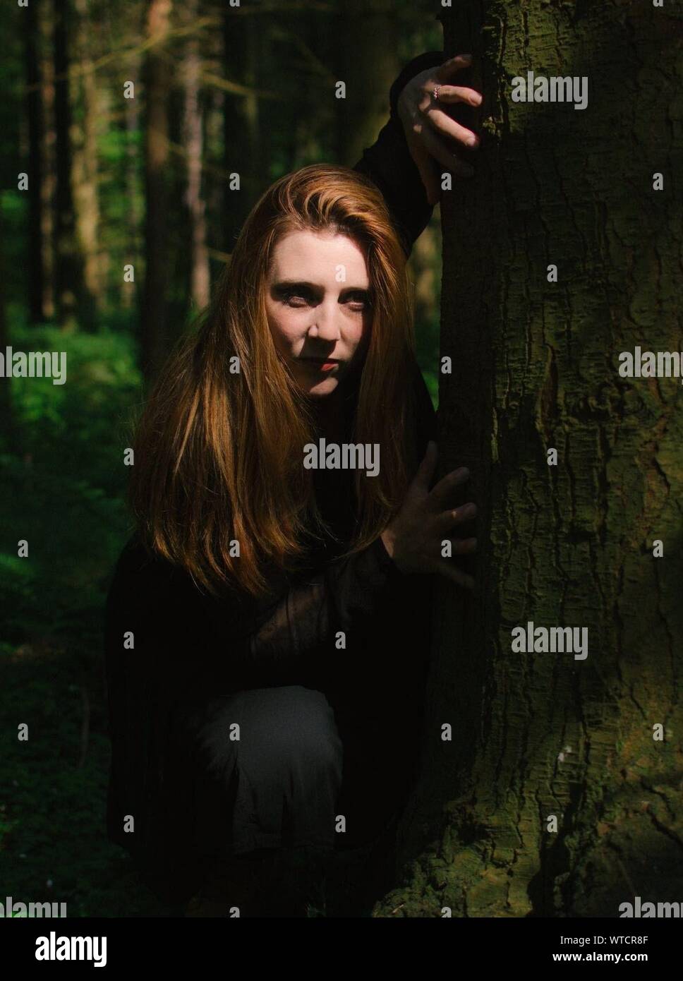 Woman hiding in the forest hi-res stock photography and images - Alamy
