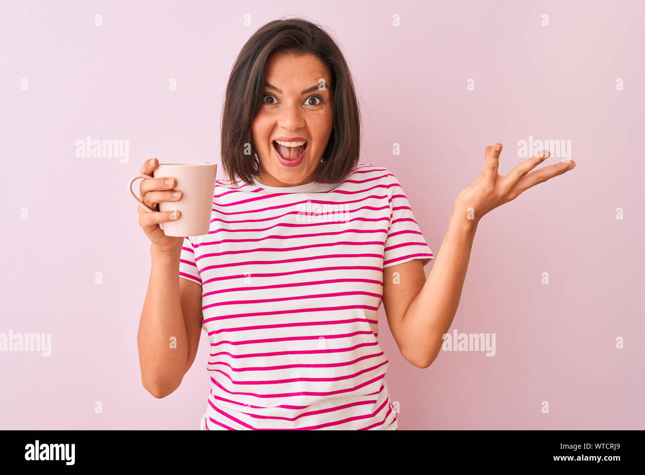 Young beautiful woman drinking cup of coffee standing over isolated ...