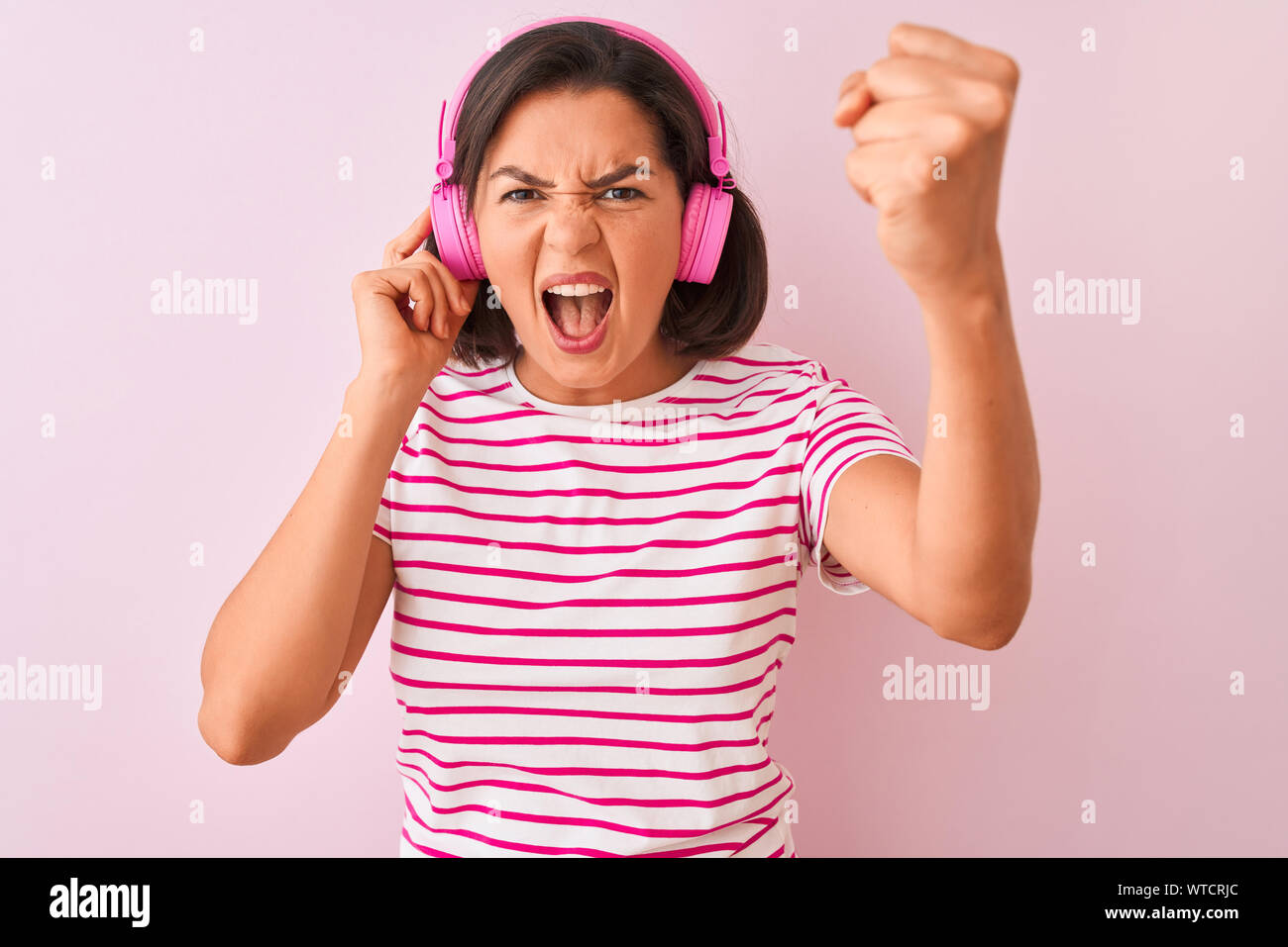 Young beautiful woman listening to music using headphones over isolated ...
