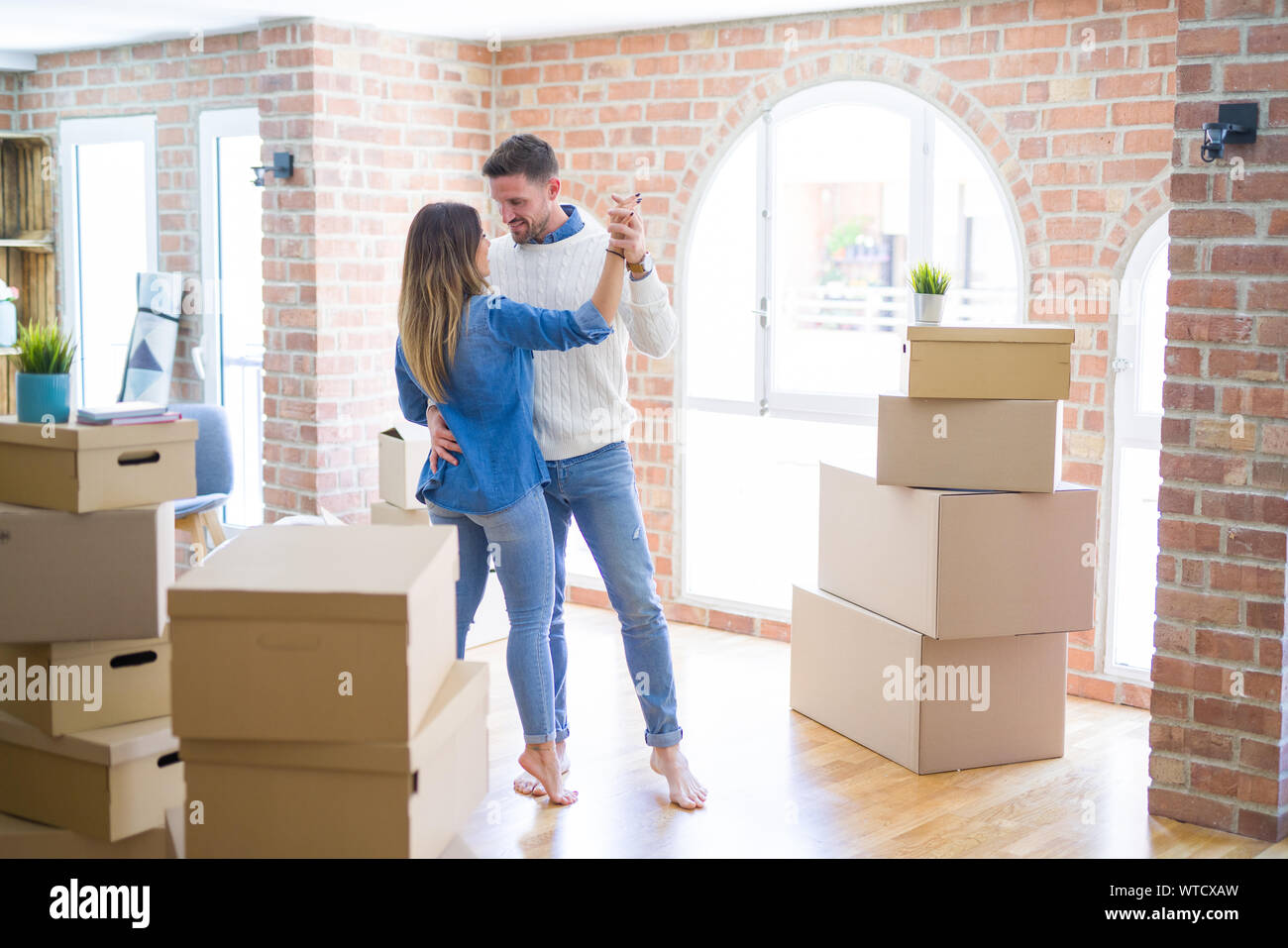 Young beautiful couple dancing at new home around cardboard boxes Stock ...