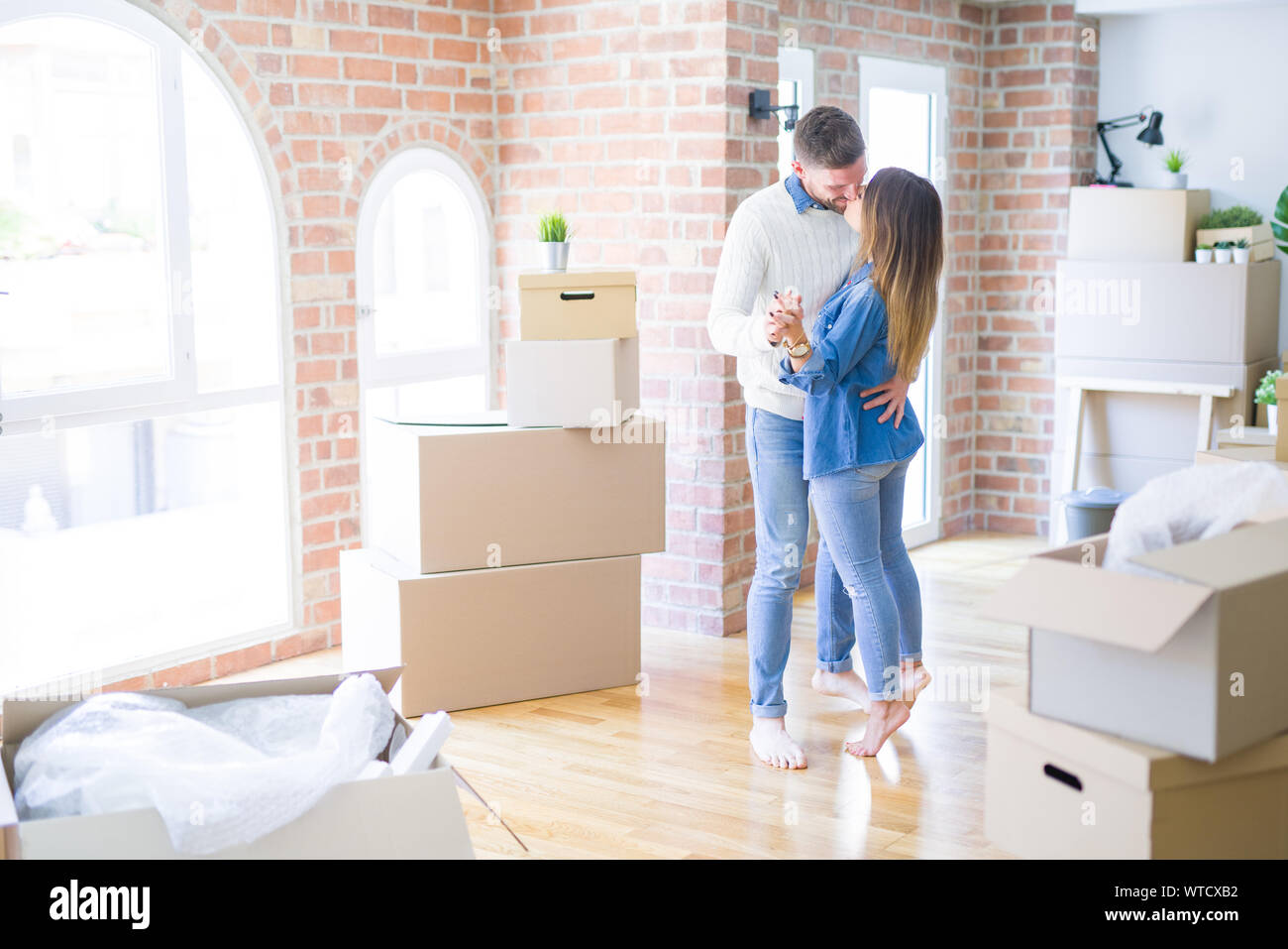 Young beautiful couple dancing at new home around cardboard boxes Stock ...