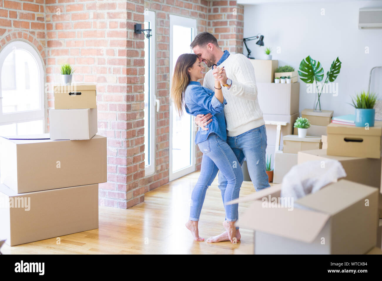 Young beautiful couple dancing at new home around cardboard boxes Stock ...