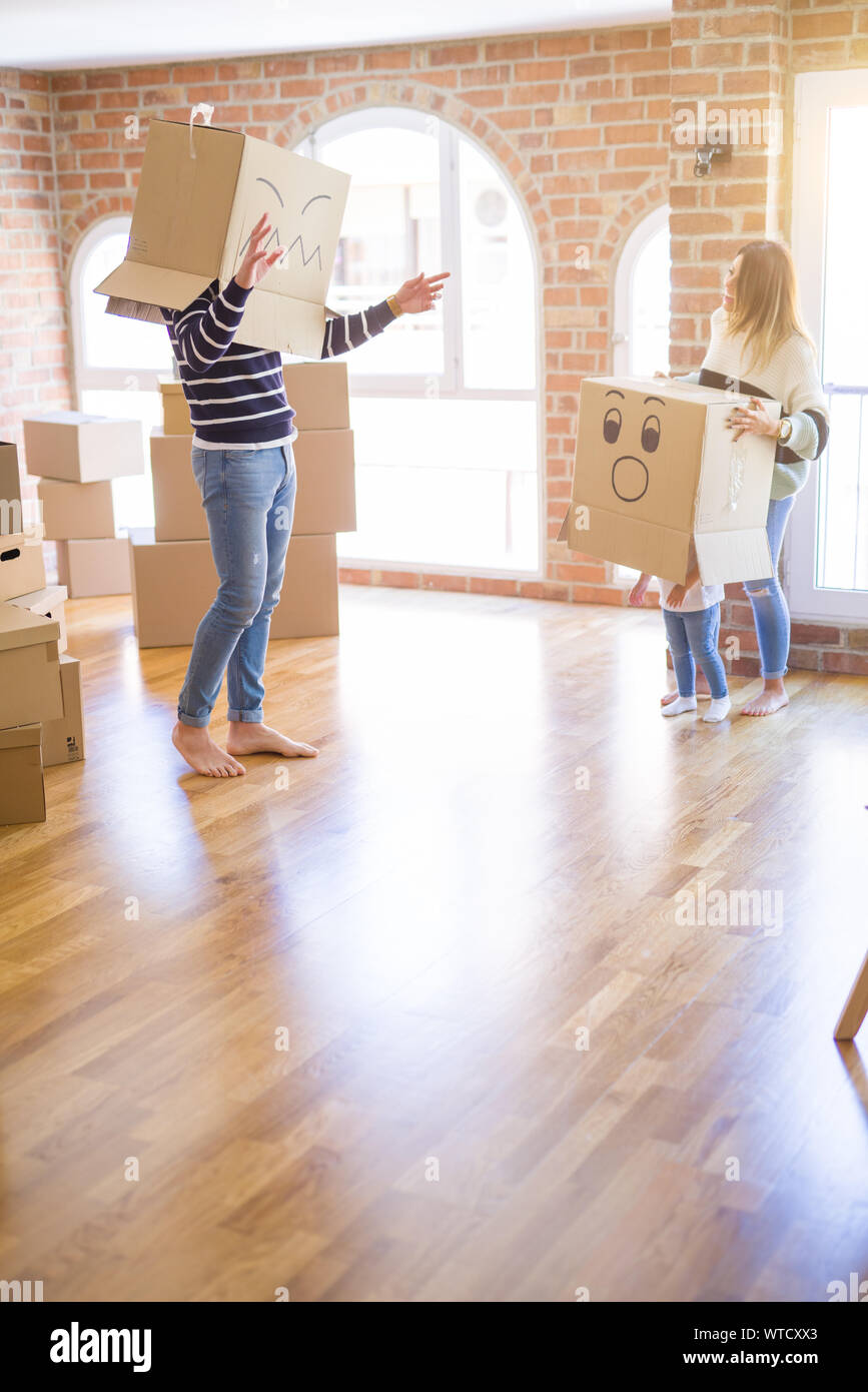 Beautiful famiily with kid playing with cardboard fanny boxes at new ...