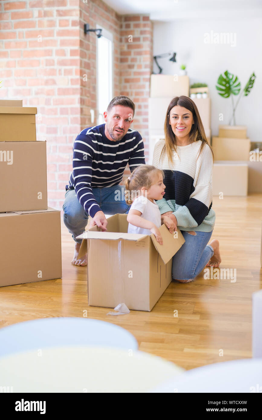 Beautiful famiily, kid playing with his parents riding cardboard fanny ...