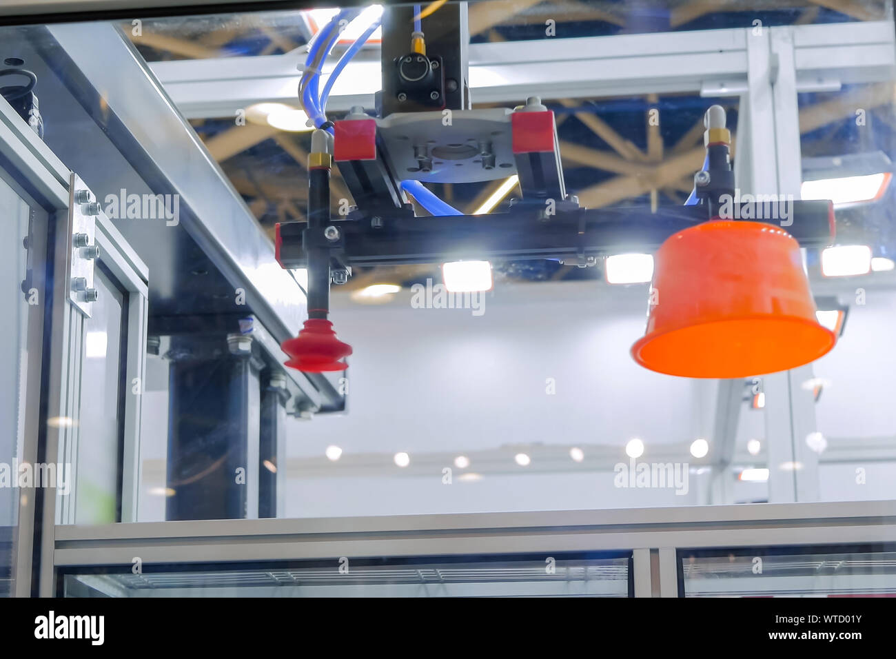 Automatic robotic arm manipulator with suction cups moves plastic pots ...