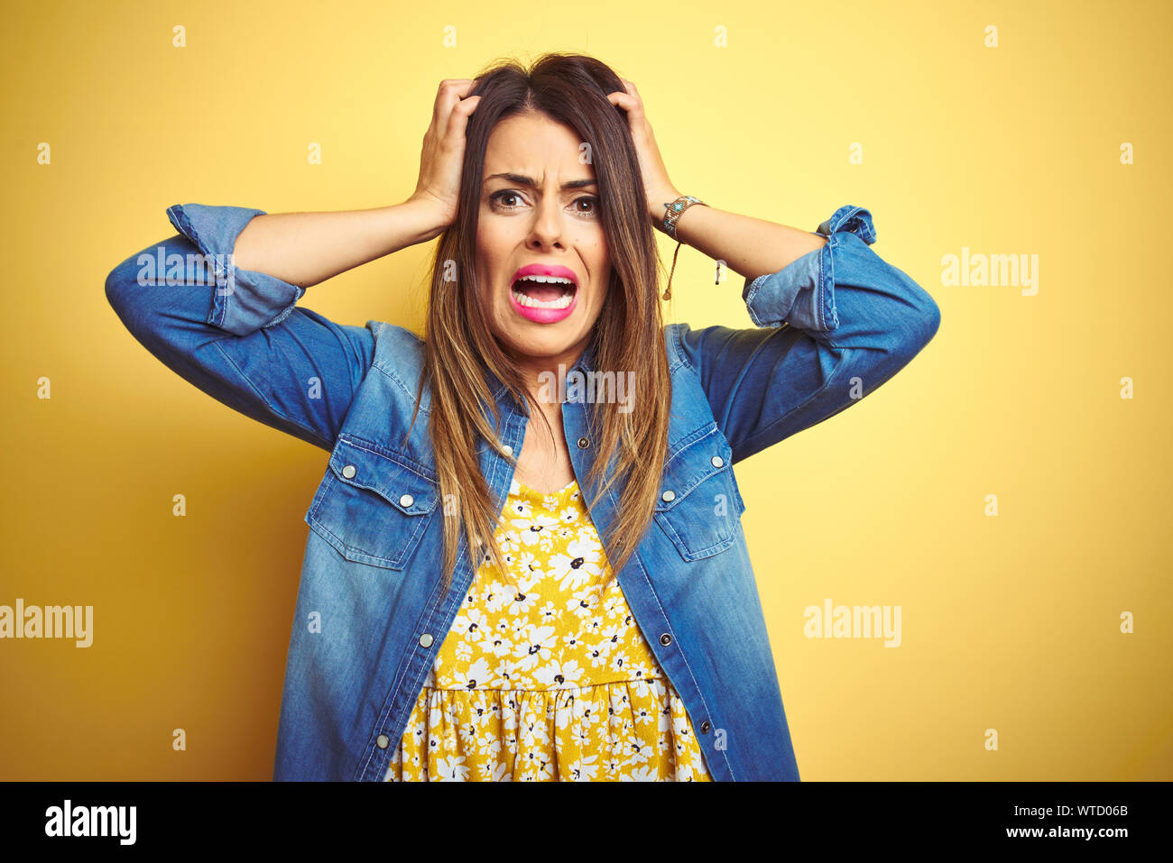 Young beautiful woman standing over yellow isolated background Crazy ...