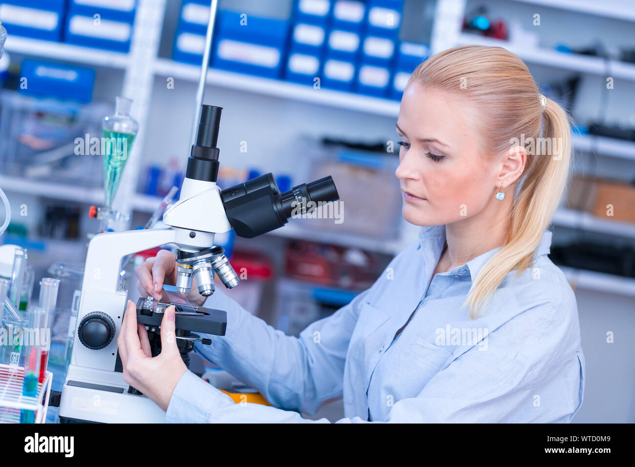 Girl with a slide for the microscope University Hospital. Attractive ...