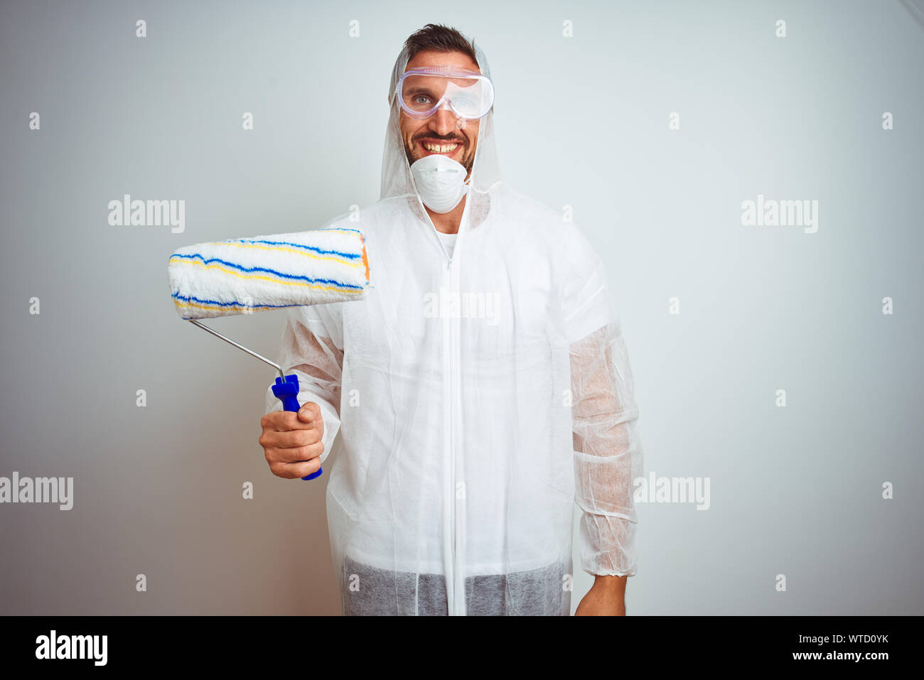 Painter man wearing professional worker equipment holding roller over ...