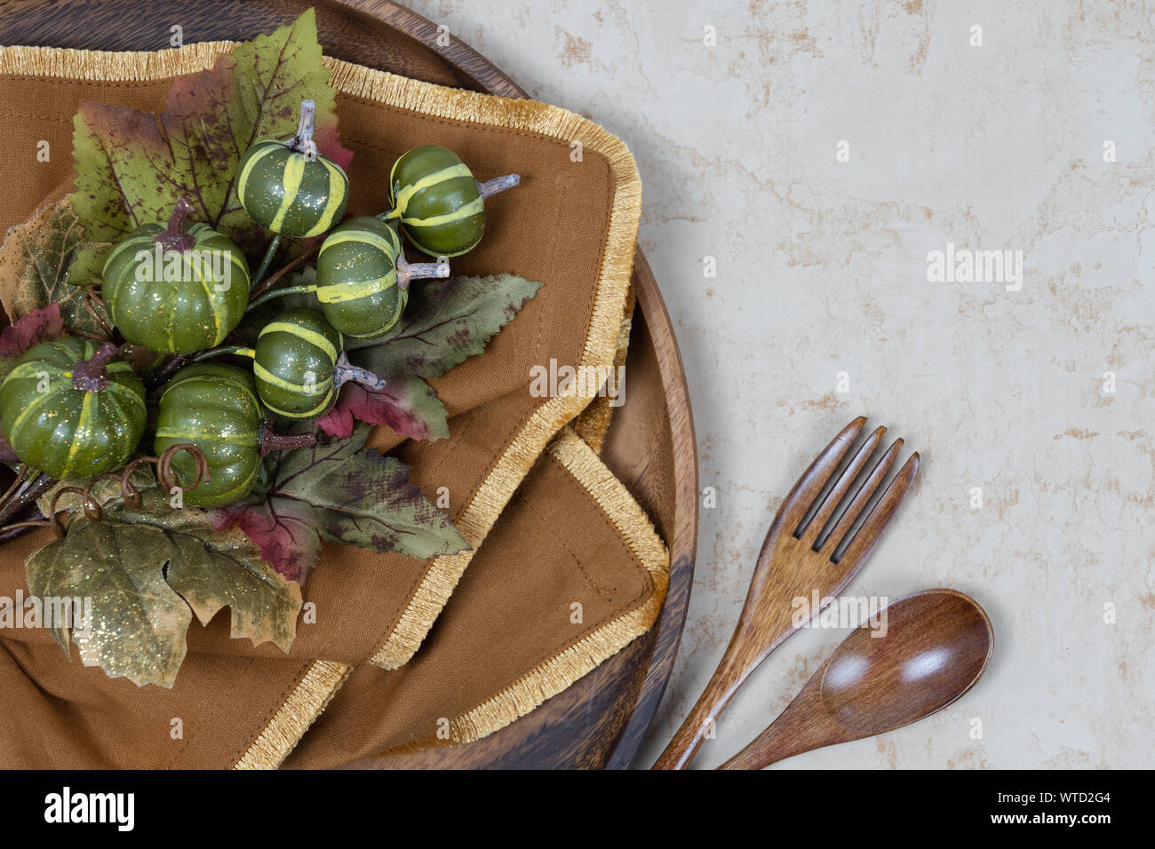 Autumn place setting with green and yellow pumpkin decor with leaves ...