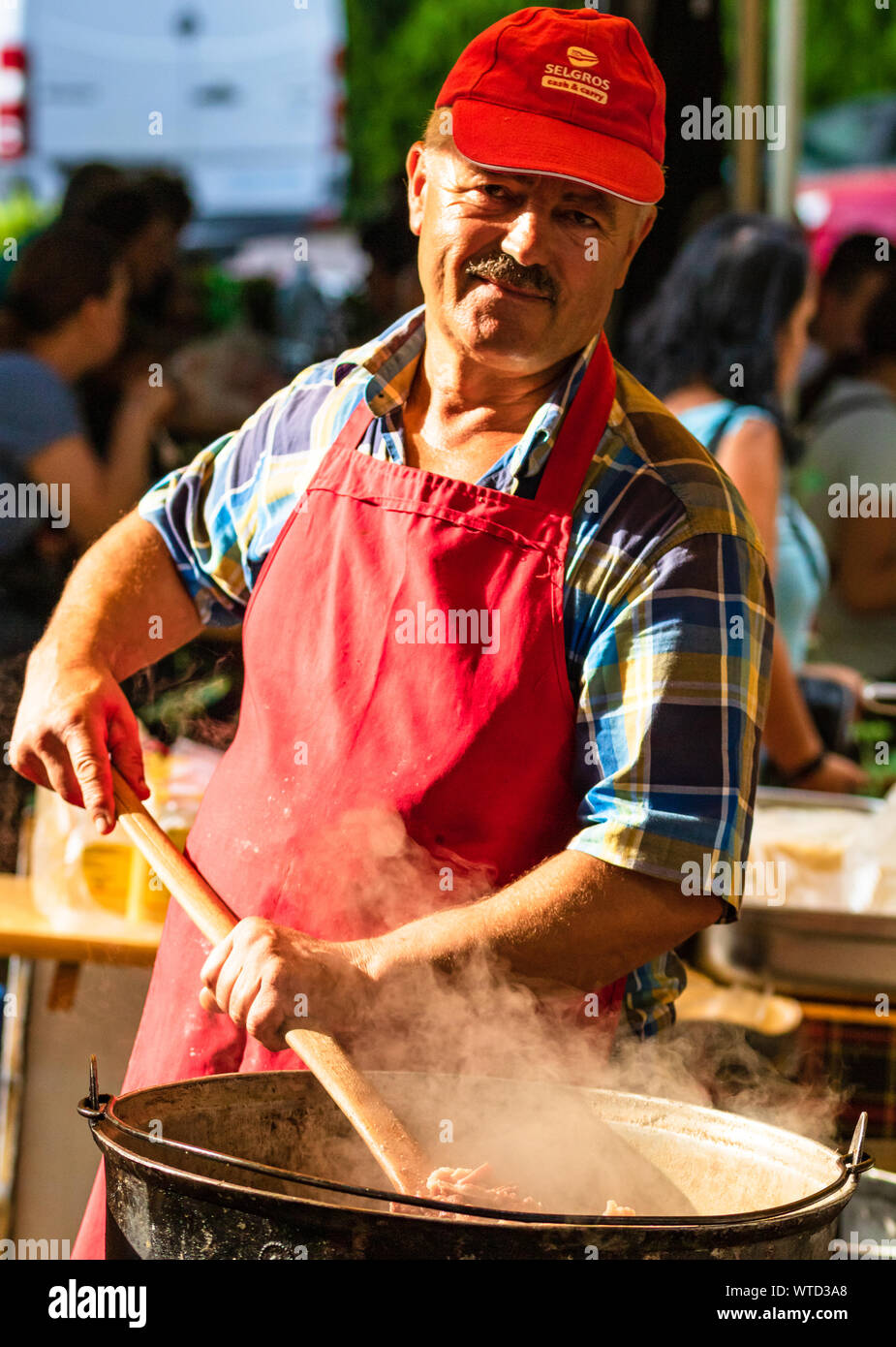 Unidentified chef preparing traditional food in the cauldron at a food ...