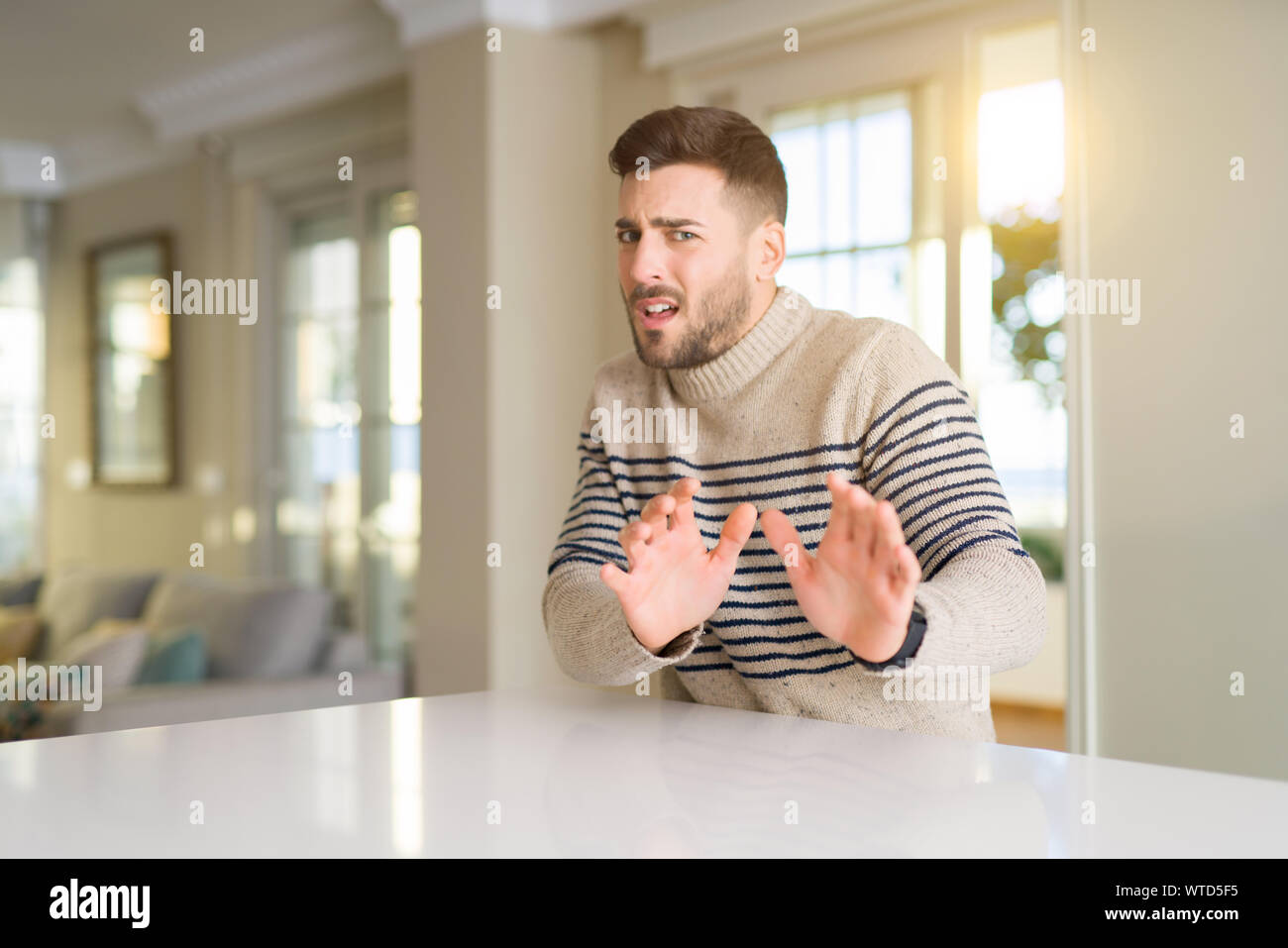 Young handsome man at home disgusted expression, displeased and fearful ...