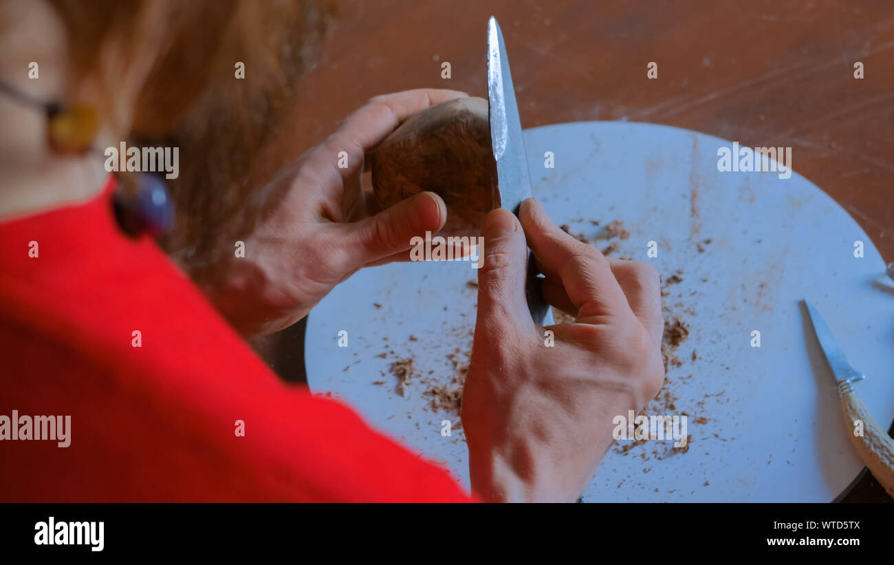 Professional potter shaping dry clay cup with special tool in pottery ...