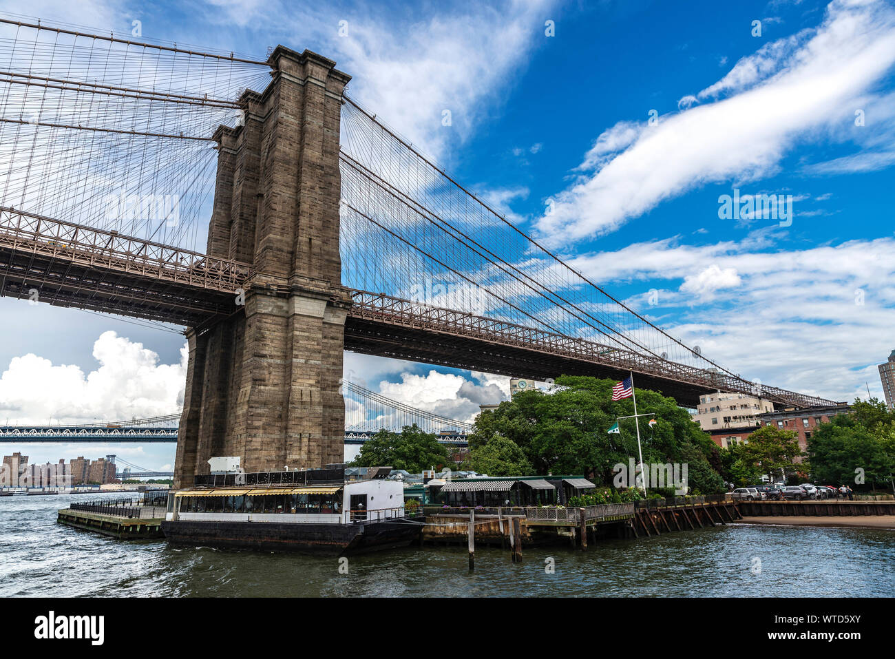 Column of the Brooklyn Bridge seen from East River in New York City ...