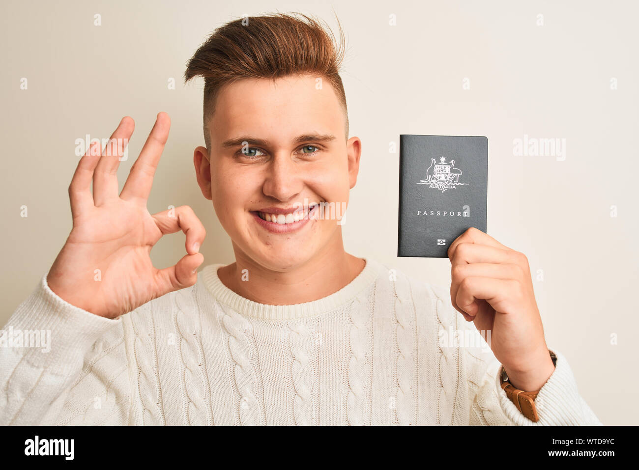 Young handsome man holding Australia Australian passport over isolated ...