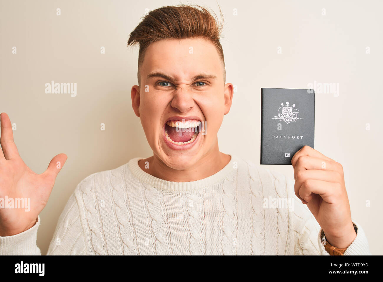 Young handsome man holding Australia Australian passport over isolated ...