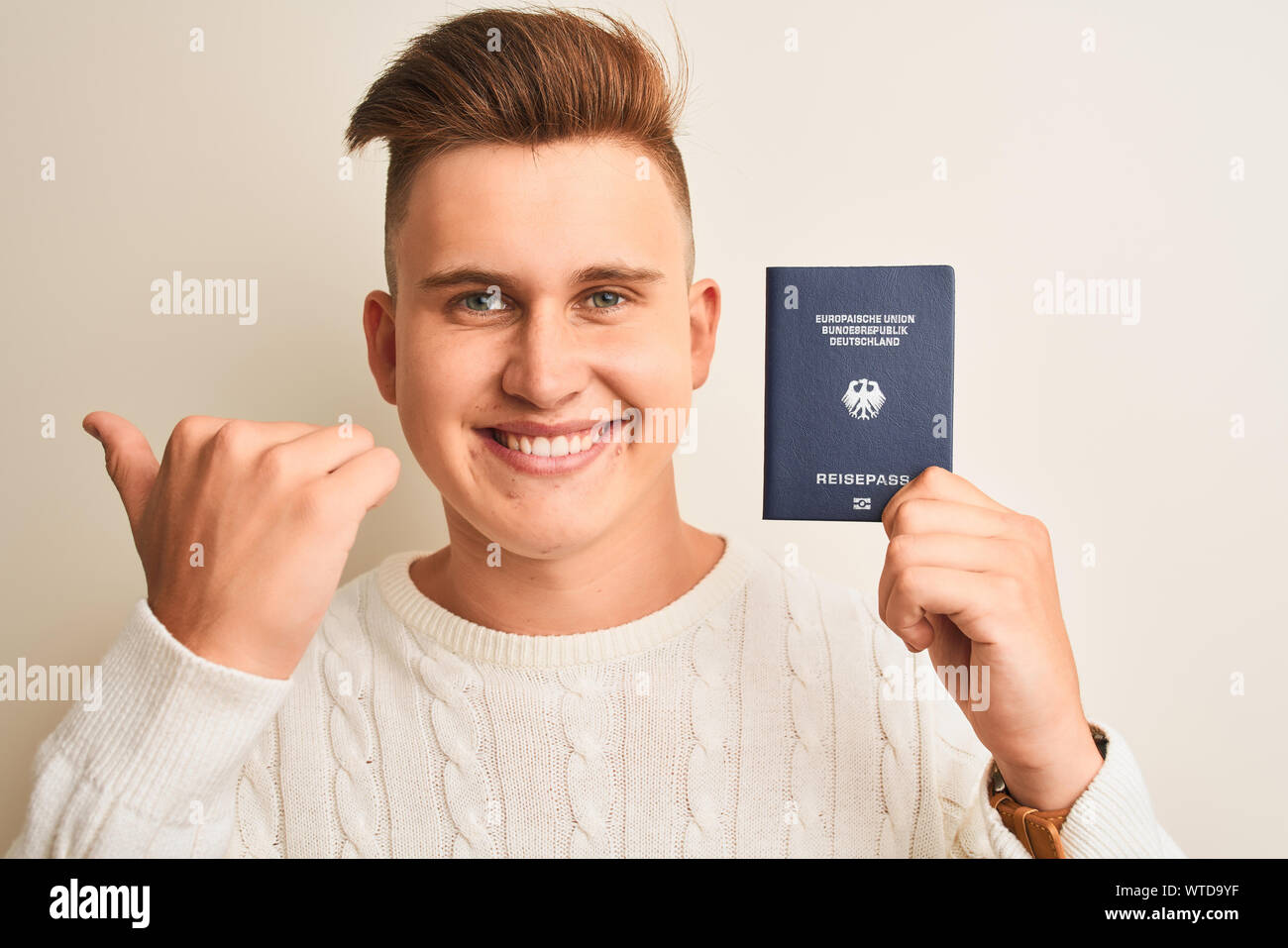 Young handsome man holding Germany German passport over isolated white ...