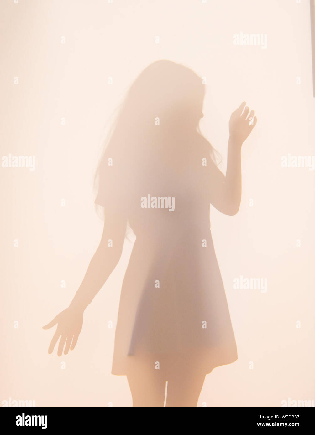 Blurred photo girl wearing dress dancing behind glass Stock Photo - Alamy