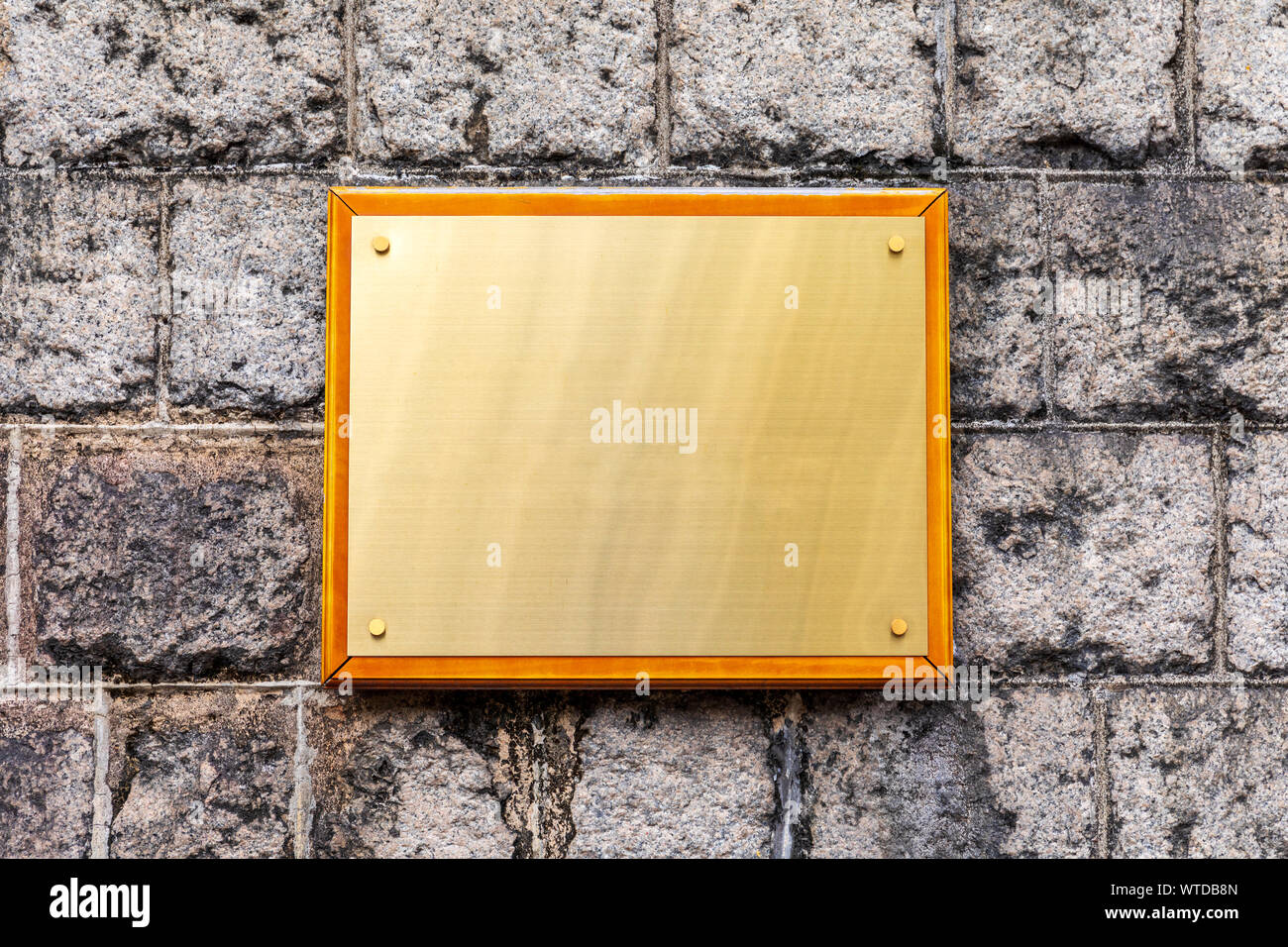 Gold Plaque Board With Frame at Stone Wall Stock Photo - Alamy