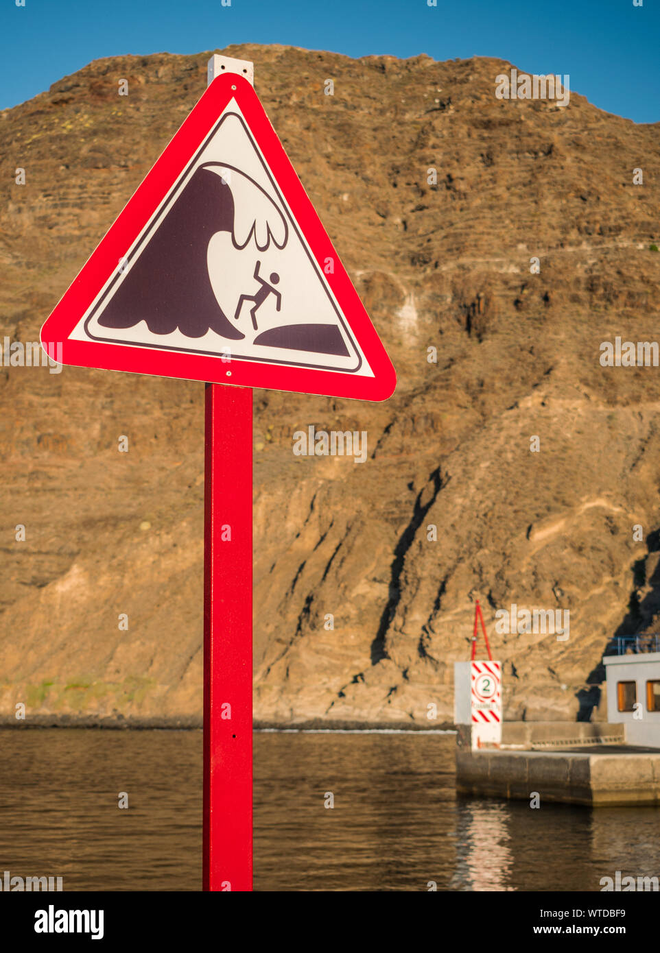 Waves warning sign with cliff background Stock Photo - Alamy