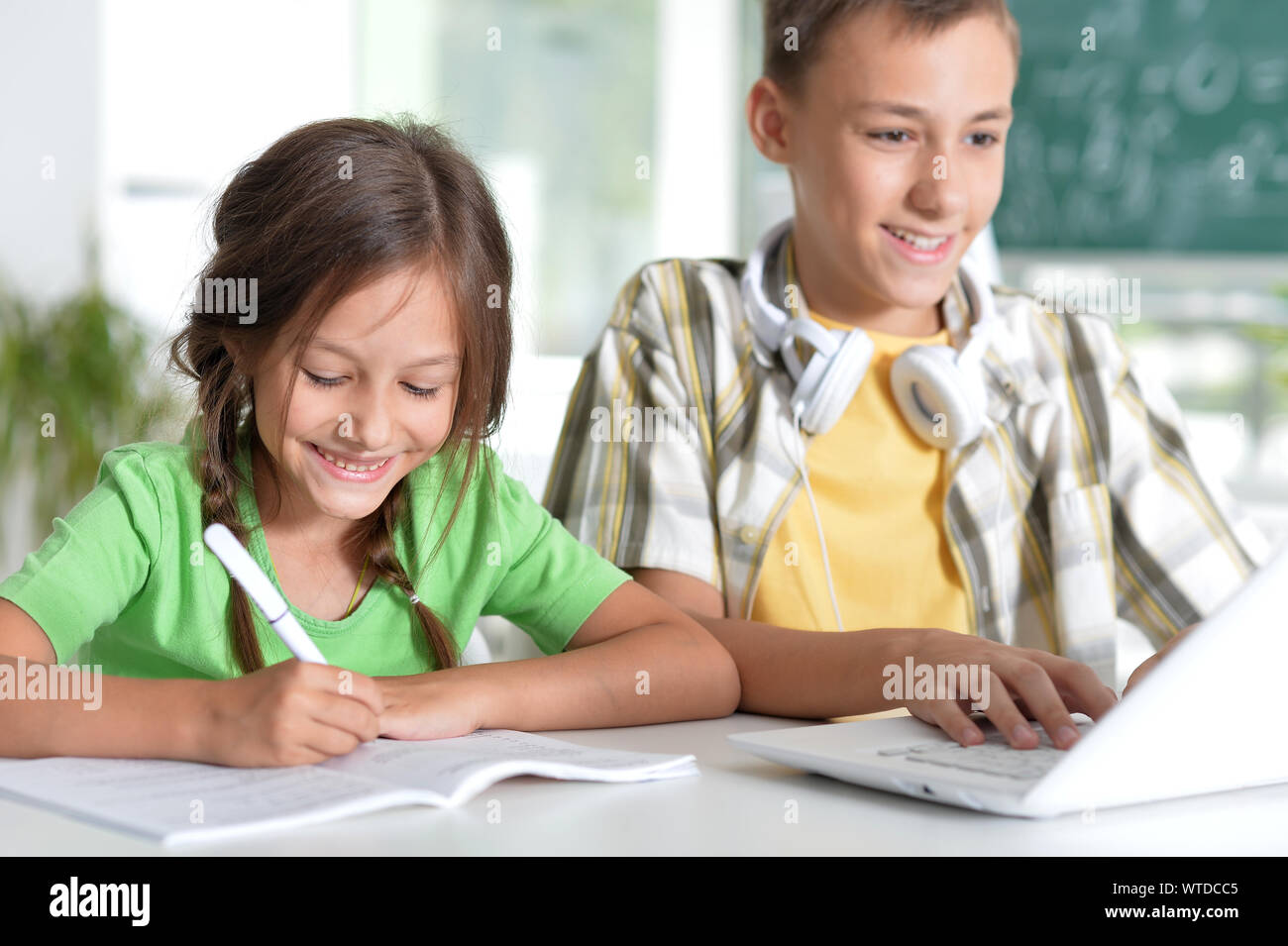 Brother and sister doing homework together at home Stock Photo - Alamy