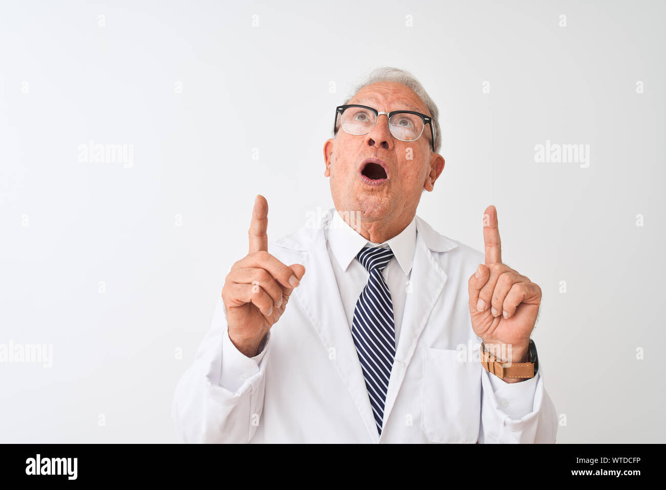 Senior grey-haired scientist man wearing coat standing over isolated ...