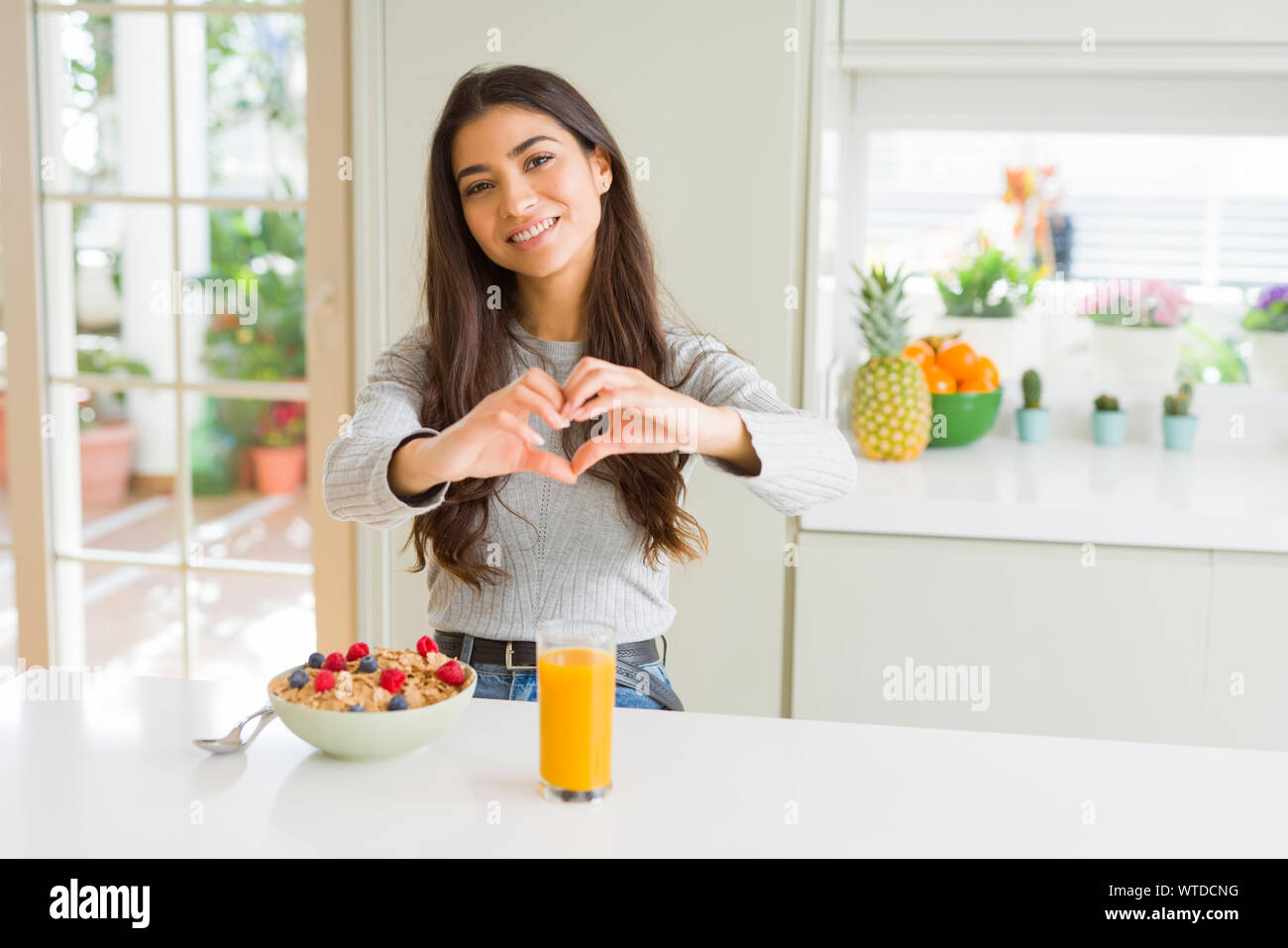 Young woman eating healthy breakfast in the morning smiling in love ...