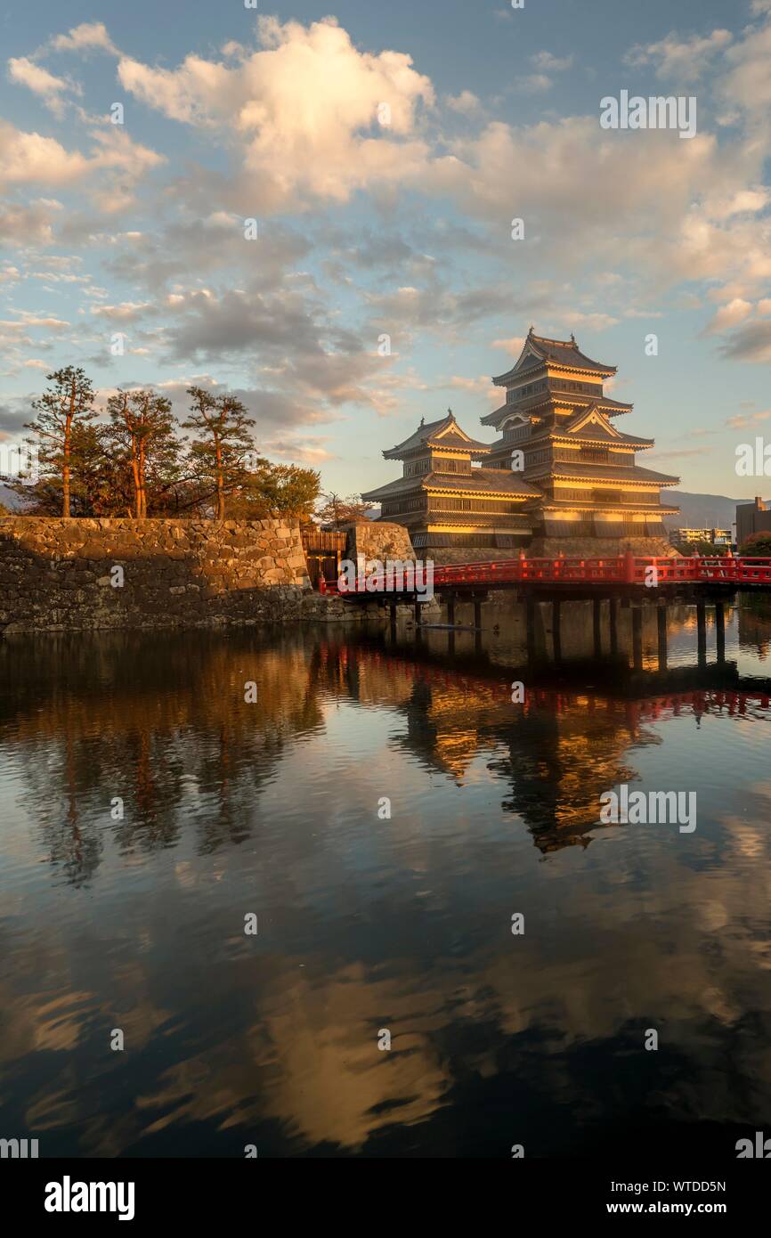 Japanese castle Matsumoto with reflection in the moat, cloudy sky at ...