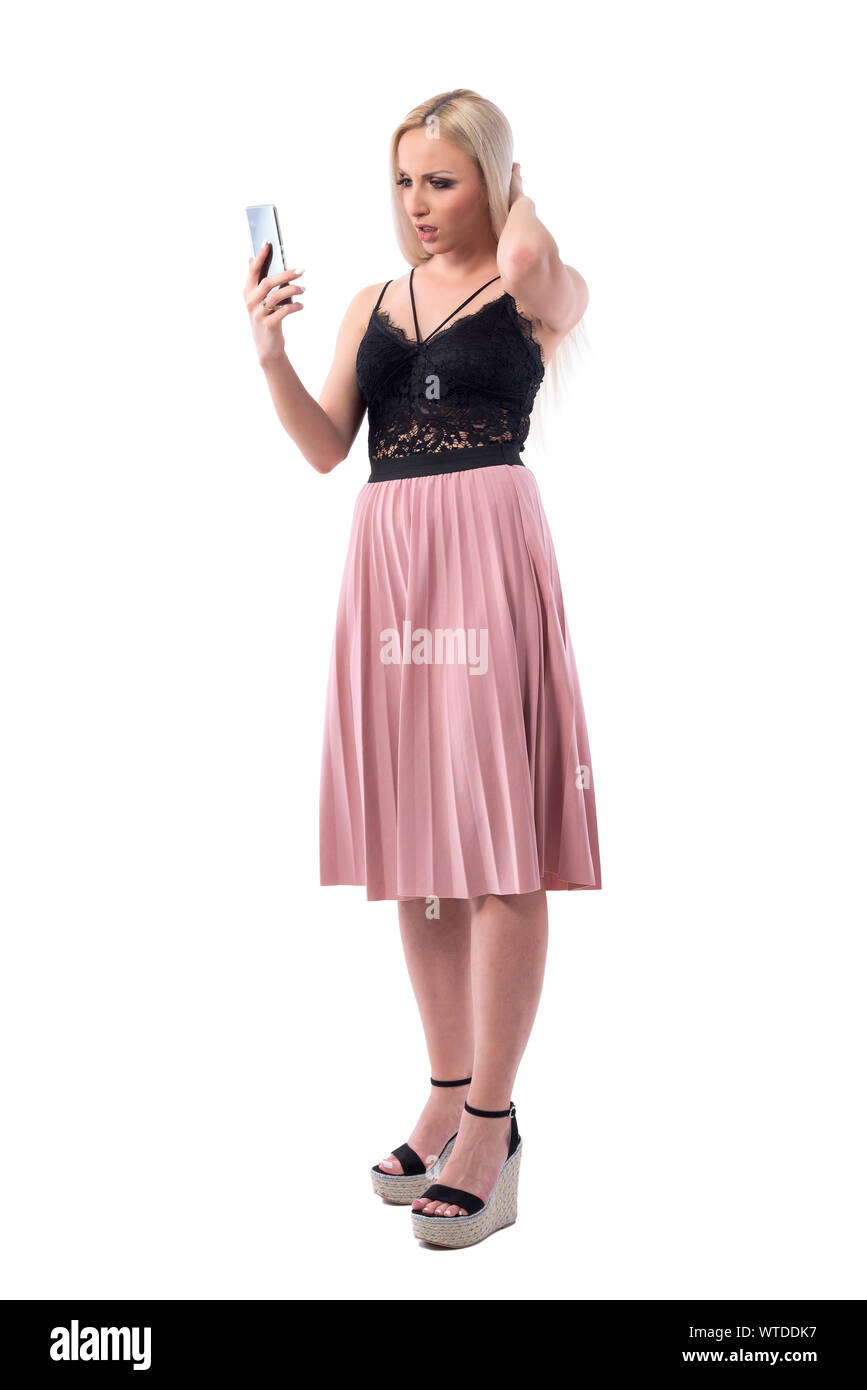 Young shocked woman looking at phone screen with angry expression. Full ...