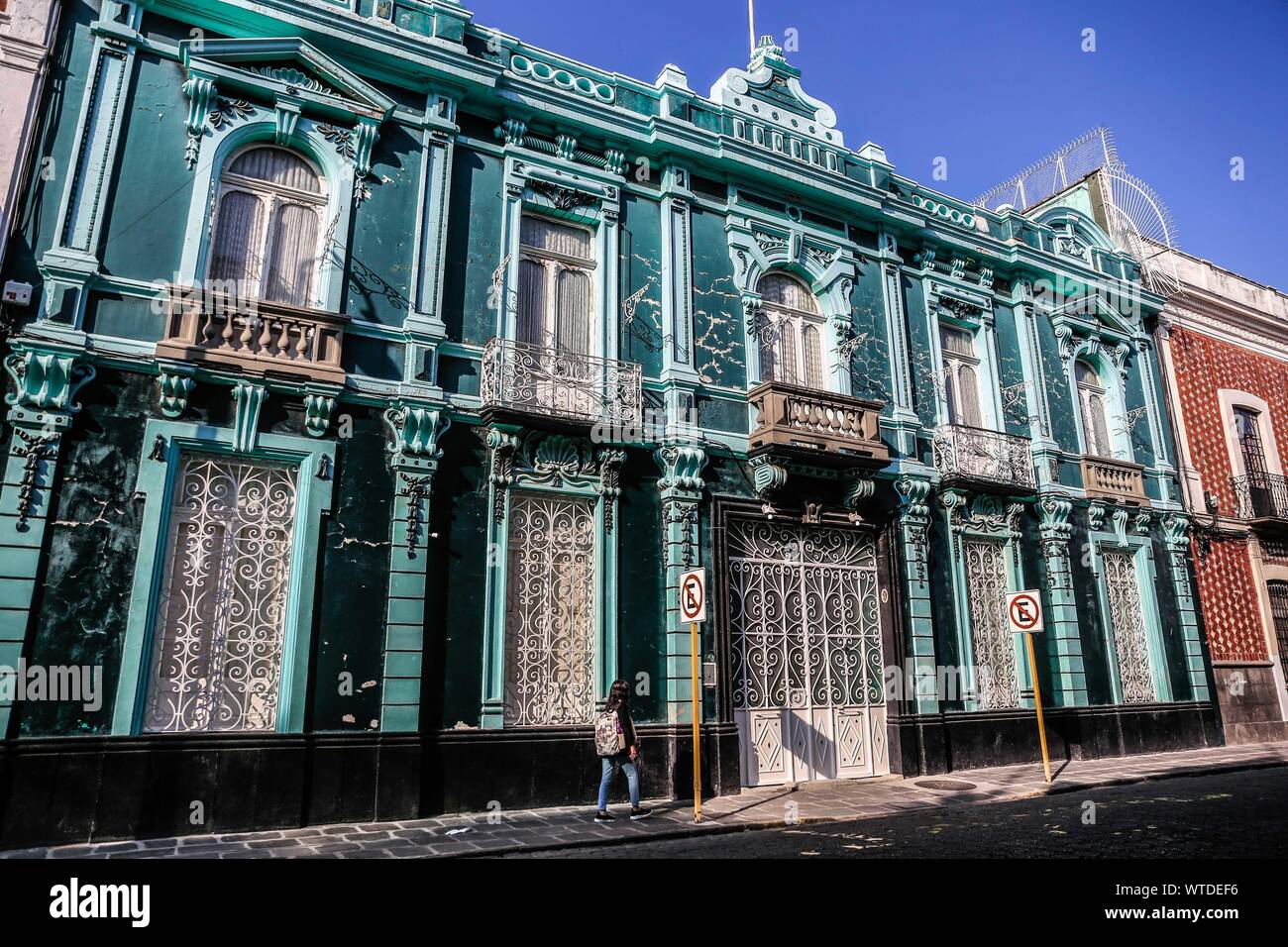 Antique Turquoise Building A Woman Walking In Front Of Turquoise Old
