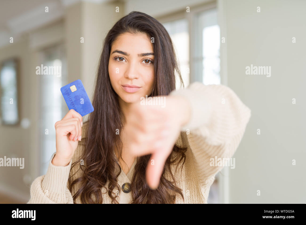 Young woman holding credit card as payment with angry face, negative ...