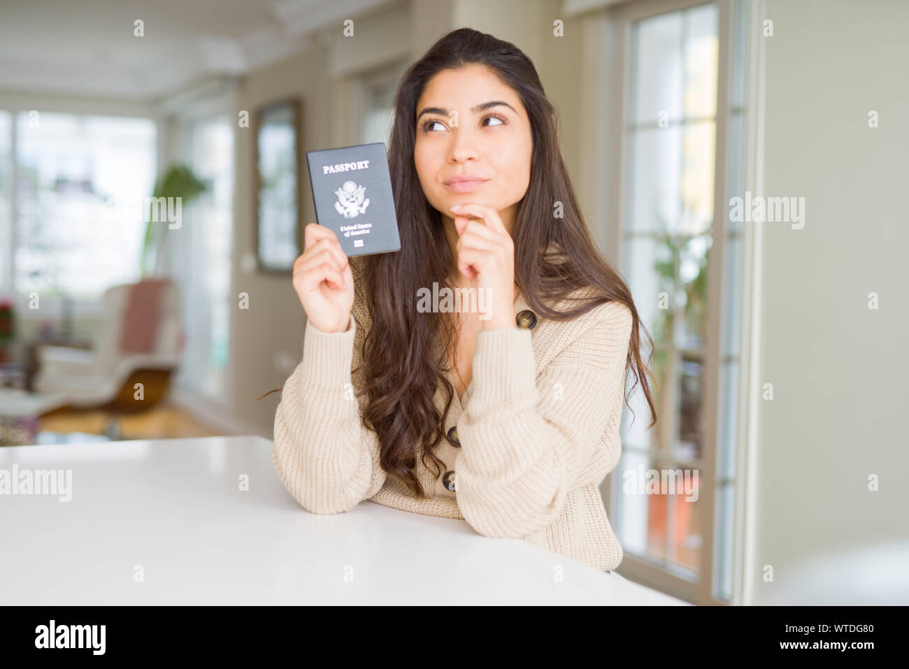 Young woman holding passport of United States of America serious face ...