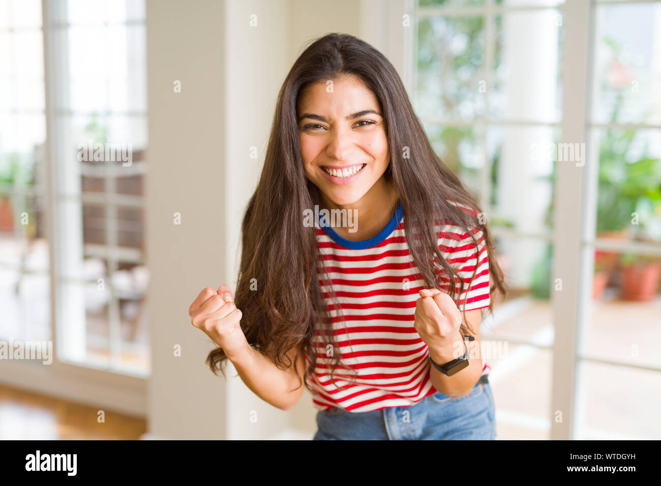 Beautiful young woman celebrating excited for success, screaming and ...