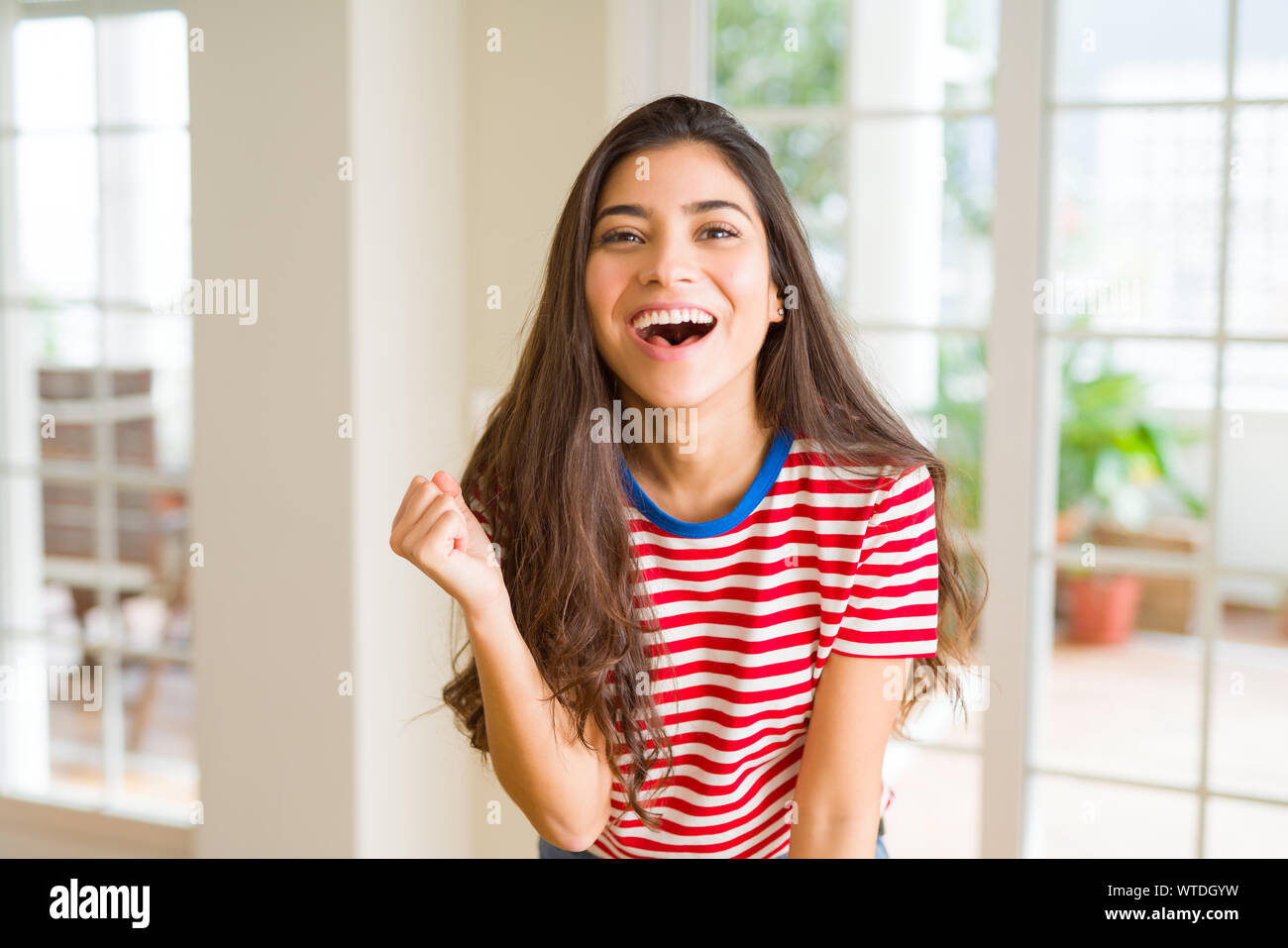Beautiful young woman celebrating excited for success, screaming and ...