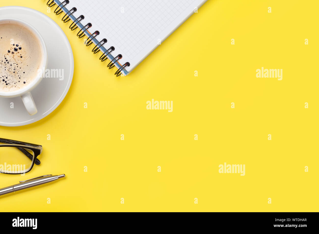 Office yellow workplace backdrop with coffee cup and supplies. Flat lay ...