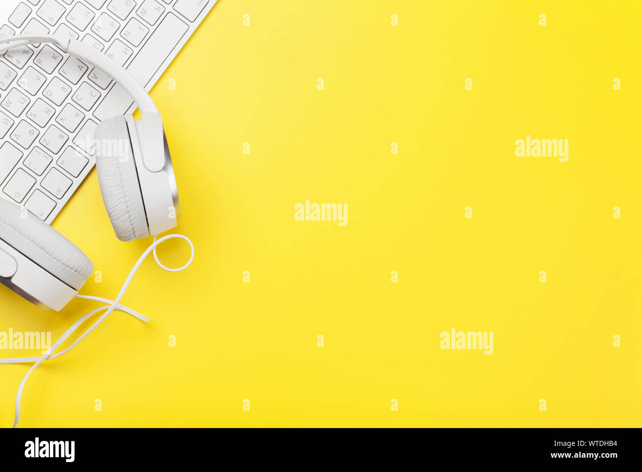 Office yellow workplace backdrop with headphones and computer. Flat lay ...