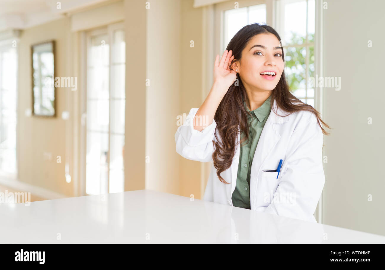Young woman wearing medical coat at the clinic as therapist or doctor ...
